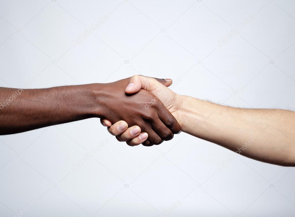 Handshake between african and a caucasian man over gray backgrou Stock ...