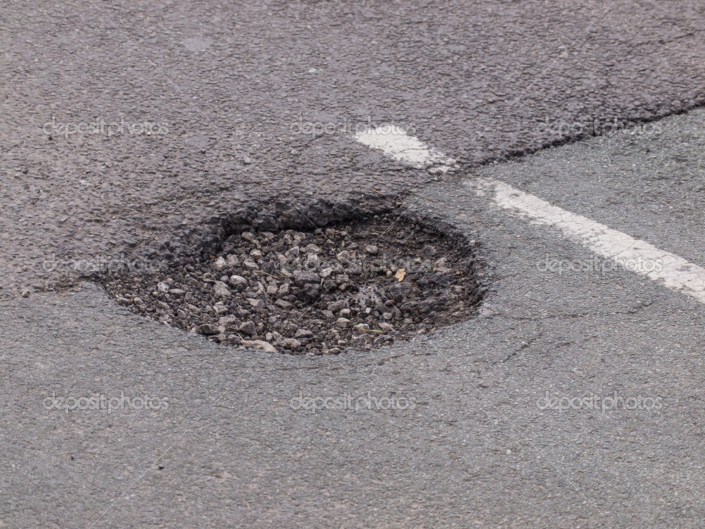 Pothole in tarmac road surface Stock Photo by ©sponner 24014493