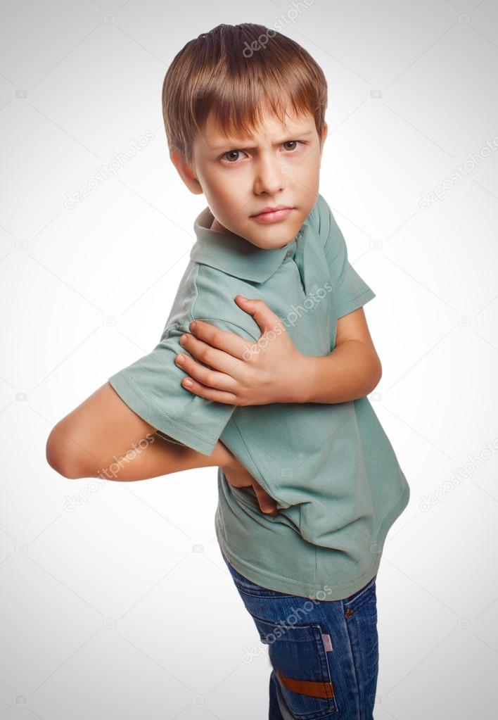 Osteochondrosis kid teenage boy isolatd holds his hand behind hi ...
