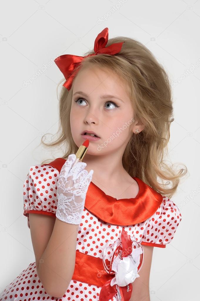 Little girl paints lips with lipstick Stock Photo by ©evdoha 13092706