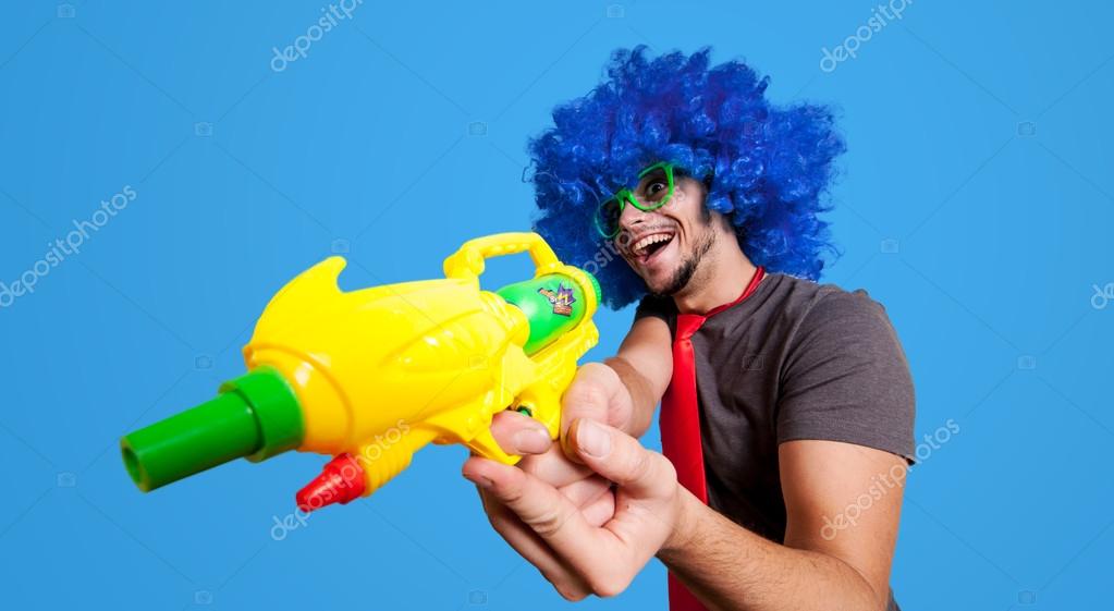 Funny guy with blue wig and water gun — Stock Photo © peus #15781437