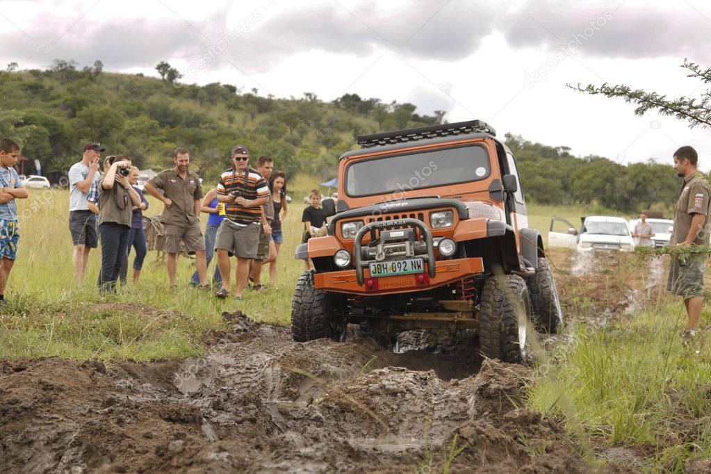 Crush Beige Jeep Wrangler Off-Roader V8 crossing mud obstacle – Stock ...
