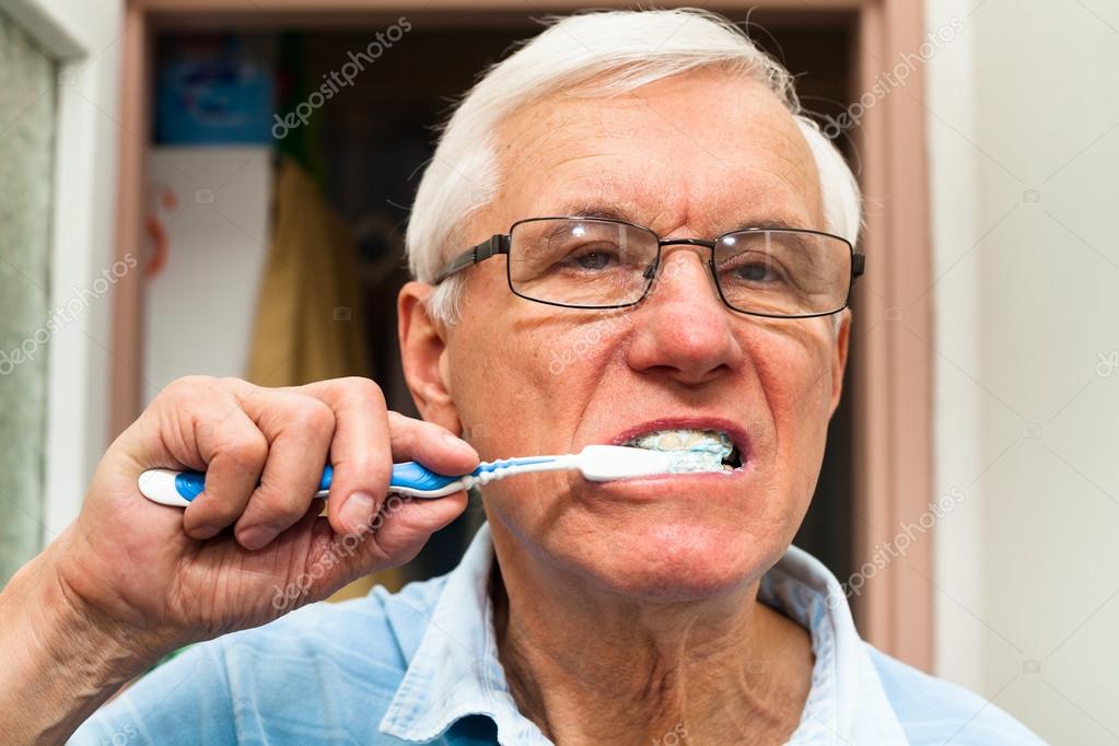 Senior man brushing his teeth — Stock Photo © JanMika #19419497