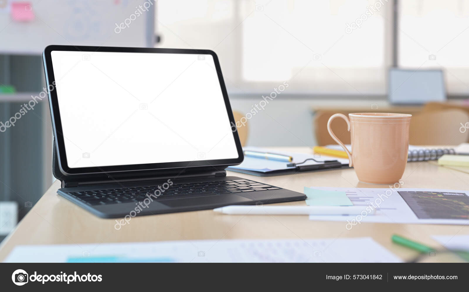 Digital tablet with wireless keyboard, coffee cup and financial ...