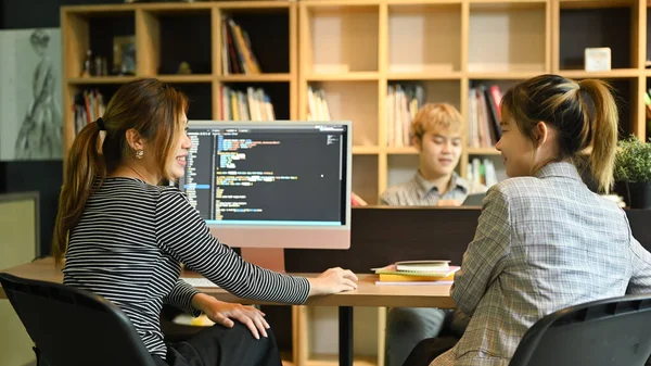 Team of software development brainstorming, working with coded data in corporate office ...