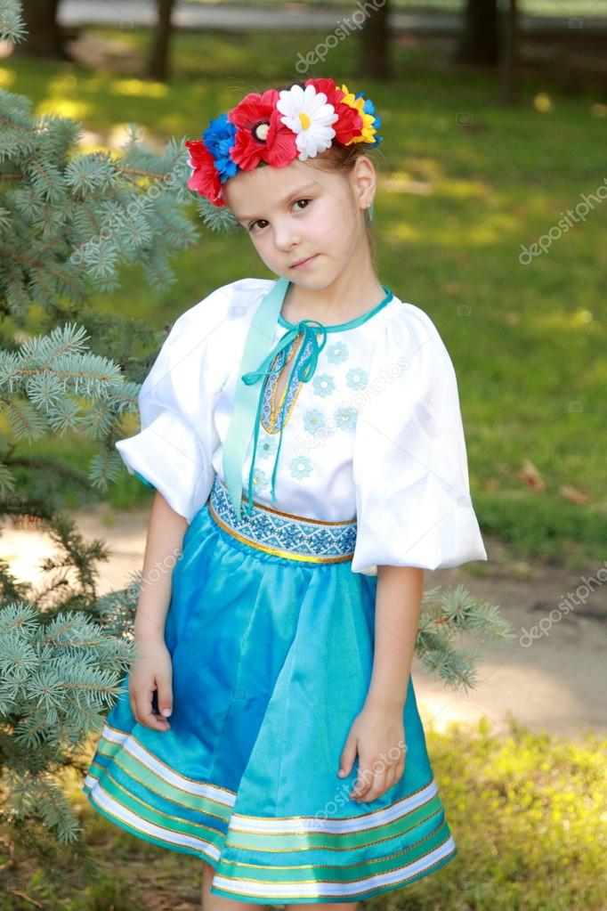 Cute little girl with a charming smile in a beautiful national costume ...