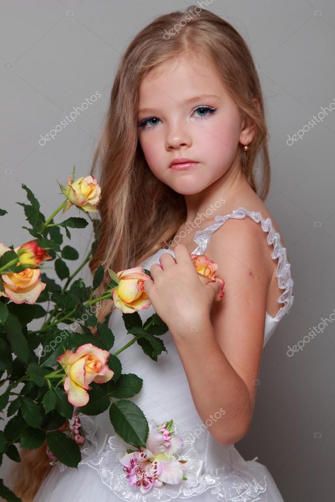 Caucasian girl with beautiful healthy long hairs holding yellow roses ...