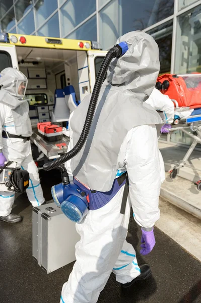 Biohazard medical team walking to building — Stock Photo ...
