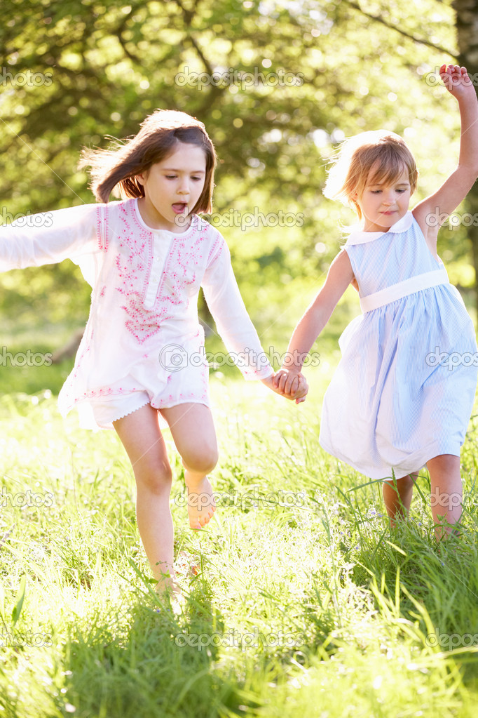 Two Young Girls Walking Through Summer Field Together — Stock Photo © monkeybusiness #24440415