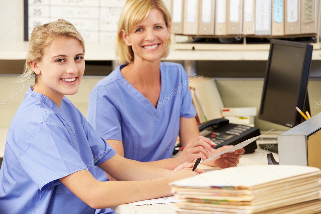 Two Nurses Working At Nurses Station Stock Photo by ©monkeybusiness ...