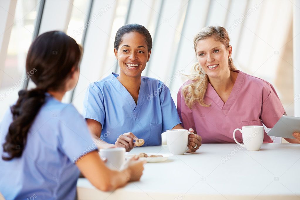 Group Of Nurses Chatting In Modern Hospital Canteen Stock Photo by ...