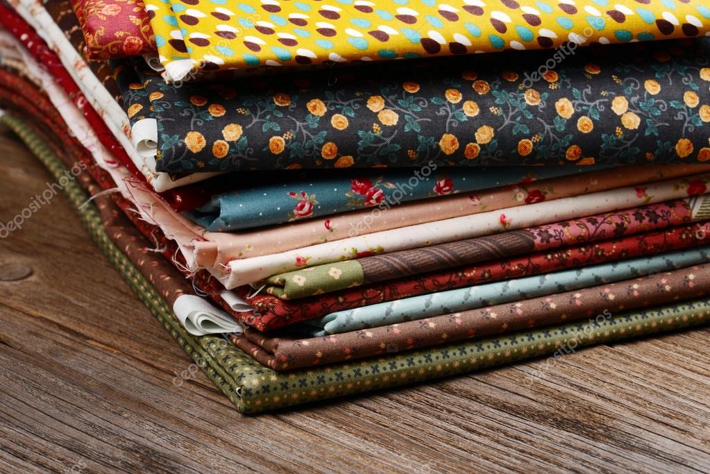 Heap of cloth fabrics on wooden table Stock Photo by ©thirteen 50285245