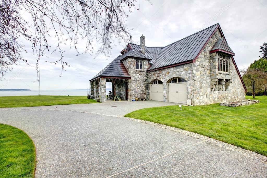 Amazing stone house with column porch and two car garage Stock Photo by ...
