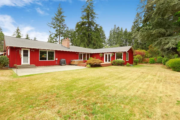 Bright red house with walkout deck and patio area Stock Photo by ...