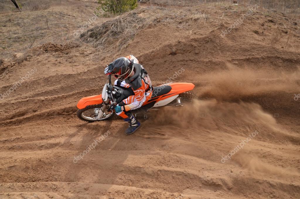 Rider at the beginning of rut turning sandy MX track Stock Photo by ...