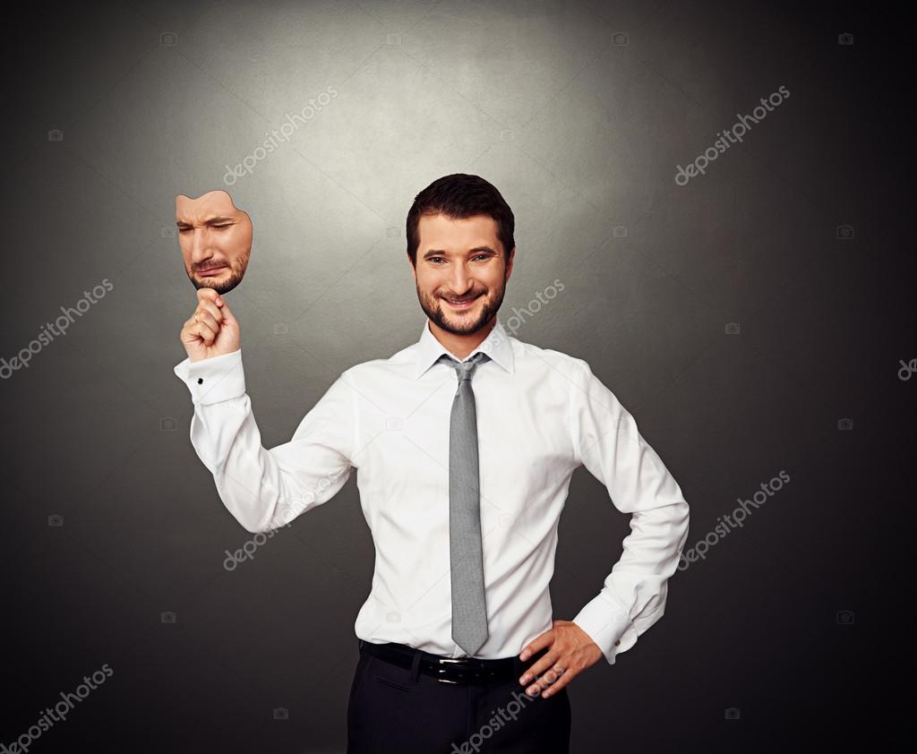Man holding sad mask Stock Photo by ©konstantynov 27436371