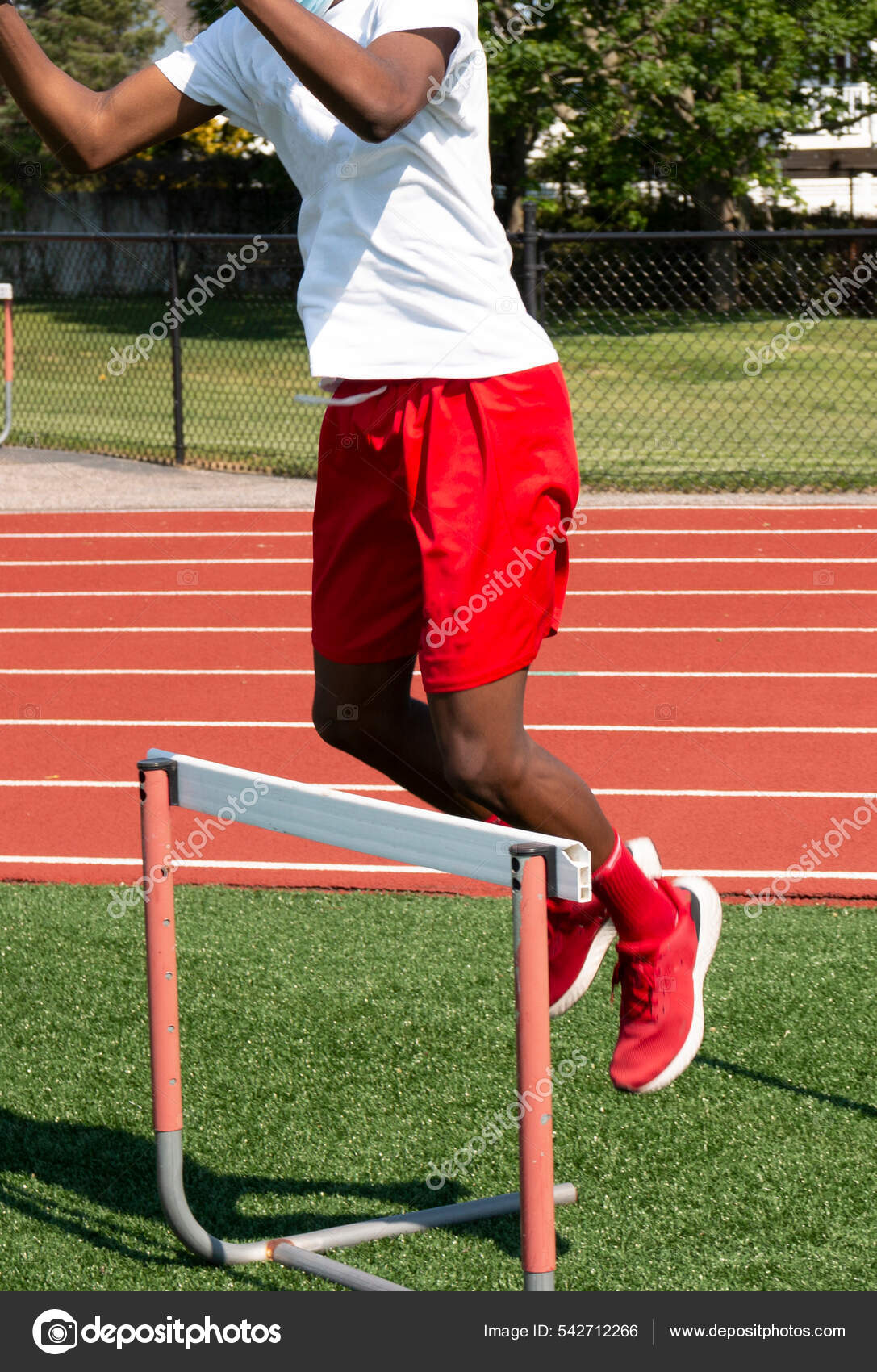 Vertical View Youn African American Athlete Jumping Track Hurdle Green ...