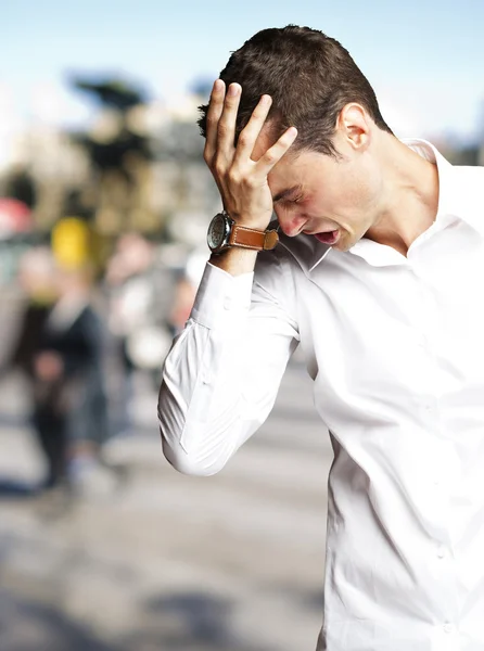 Angry young man doing frustration gesture at crowded place - Stock ...
