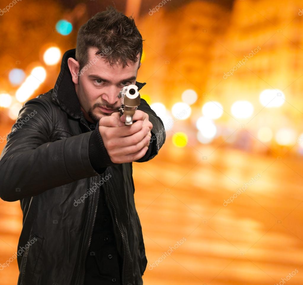 Young man pointing with gun — Stock Photo © Krakenimages.com #19531215