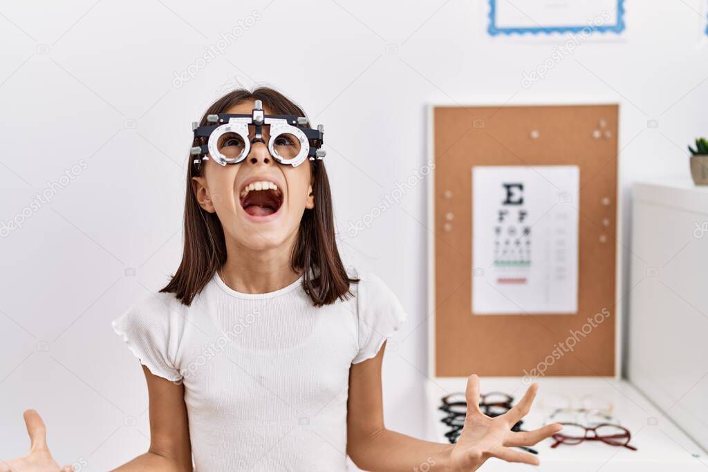 Chica hispana joven con gafas de optometría loca y loca gritando y ...