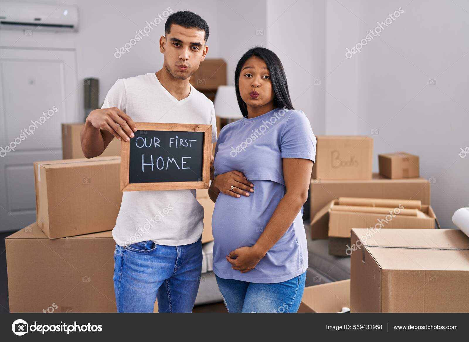Young Hispanic Couple Expecting Baby Moving New Home Puffing Cheeks ...