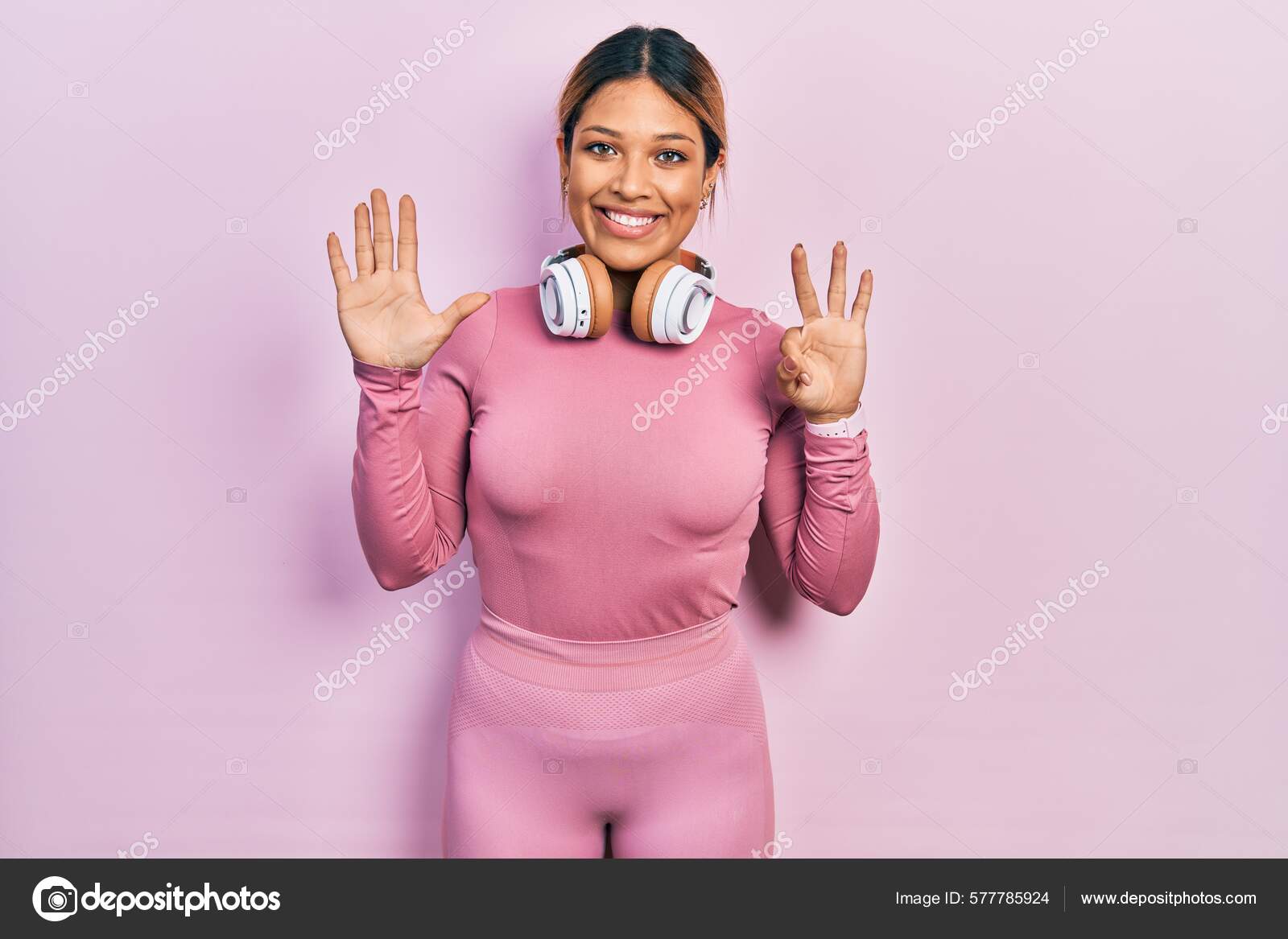 Beautiful Hispanic Woman Wearing Gym Clothes Using Headphones Showing ...