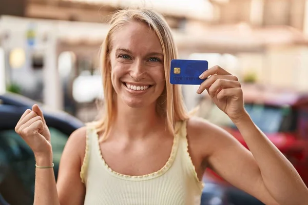 Young caucasian woman holding credit card screaming proud, celebrating ...