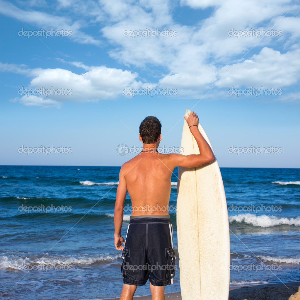 Boy surfer back view holding surfboard on beach — Stock Photo ...
