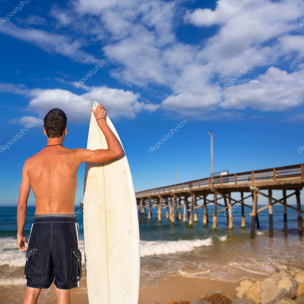 Boy surfer back view holding surfboard on beach Stock Photo by ...