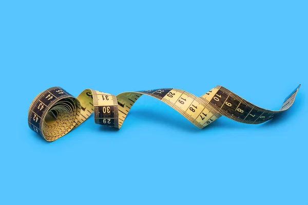 Yellow measuring tape on a blue background. Tool for measuring length ...