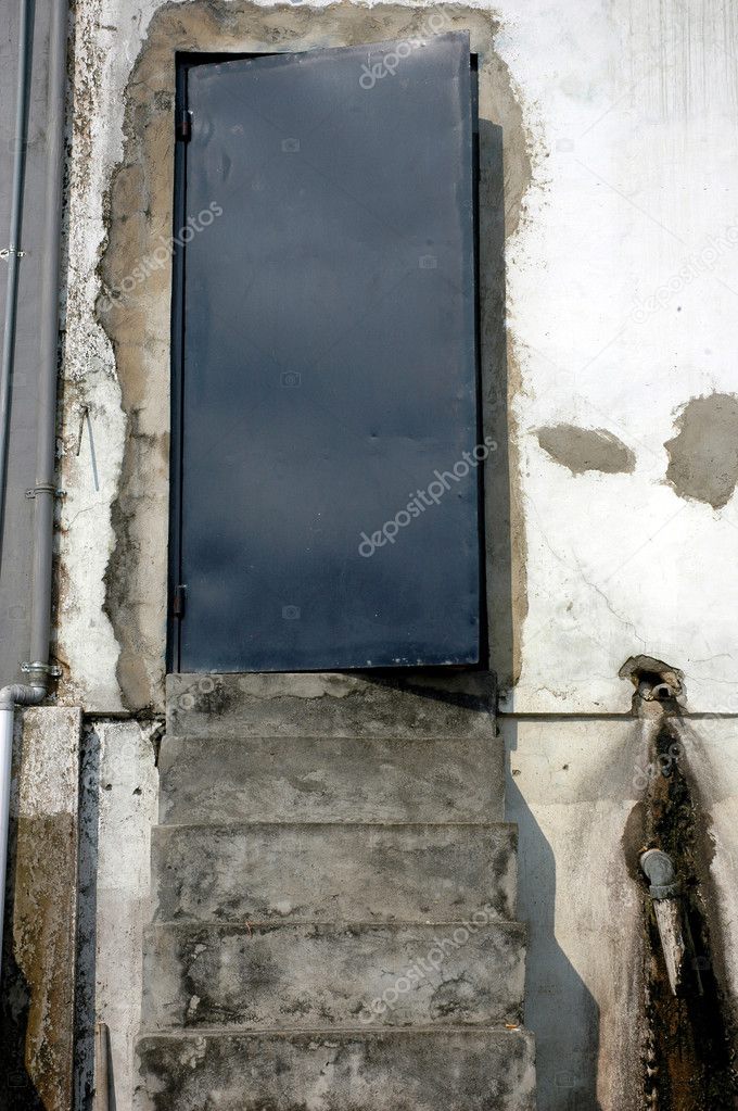 Concrete stairs leading to a black metal door — Stock Photo © tempakul ...