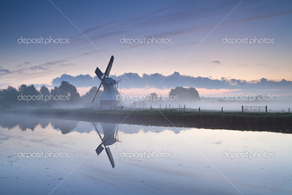 White Dutch windmill by river in misty sunrise Stock Photo by ©O ...