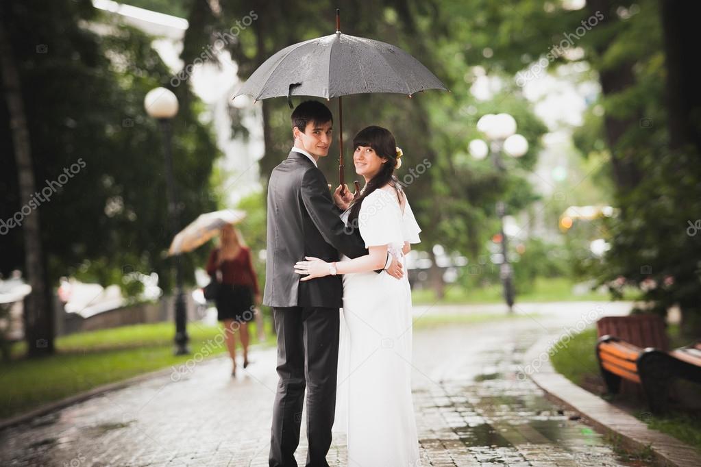Newly married couple walking in park under rain Stock Photo by ©Kryzhov ...