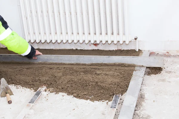 Mason leveling the cement screed - Stock Image - Everypixel