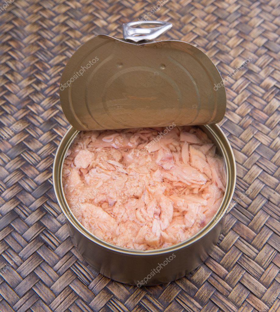 Trozos de atún en una lata sobre fondo de mimbre 2024