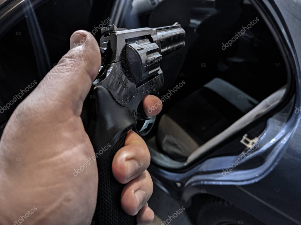 gran pistola negra. viejo revólver. pistola y auto. 2023