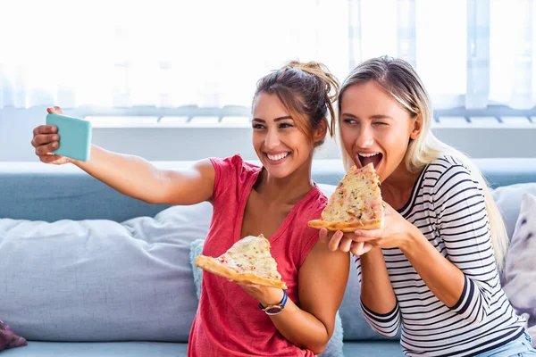 Friends eating pizza and smiling for selfie. They are sharing pizza and ...
