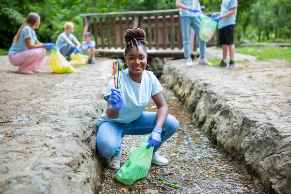 Woman handpicking gathering up garbage plastic straws garbage from the ...