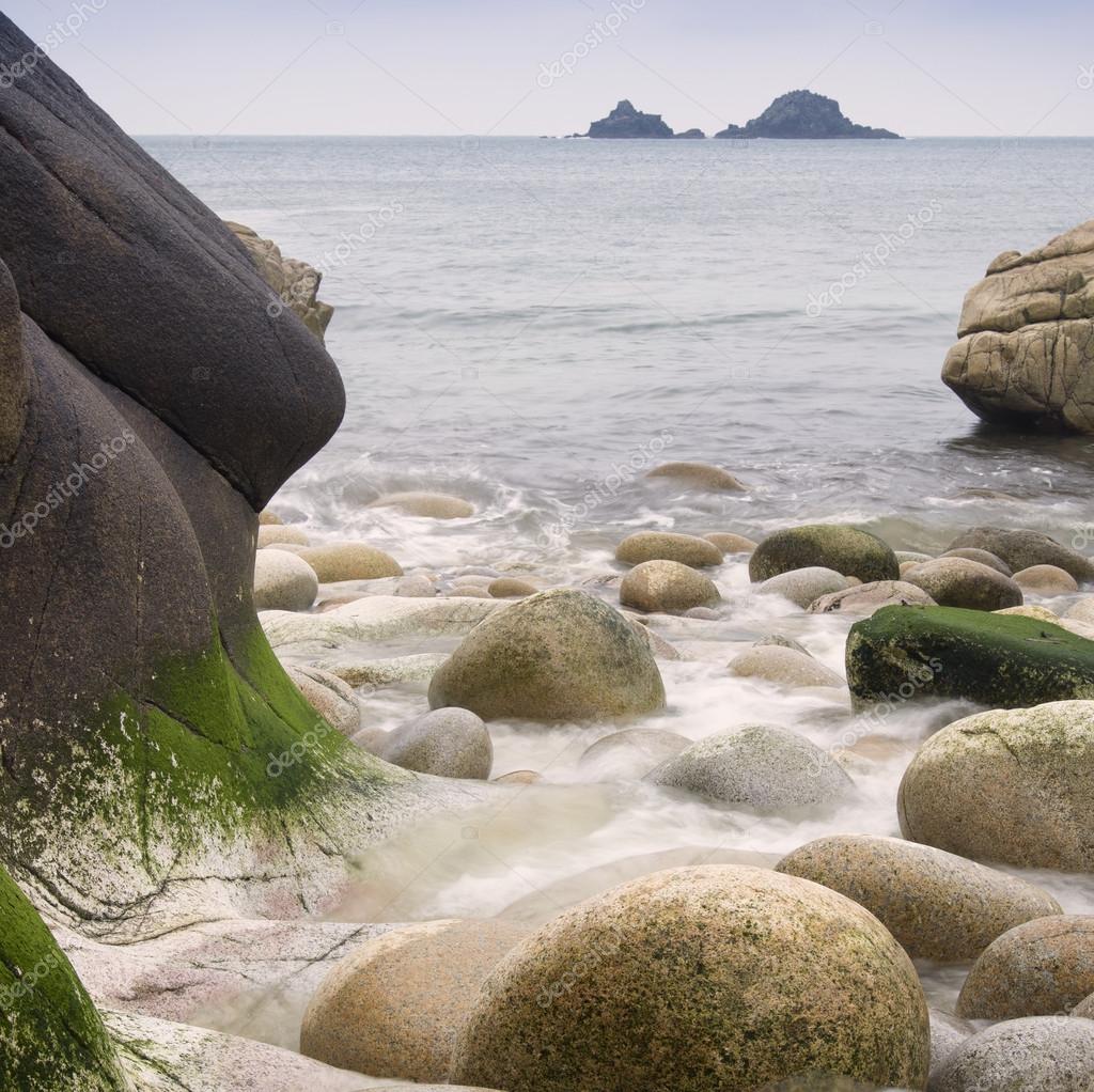 Water worn ancient rocks detail on secluded beach Stock Photo by ...