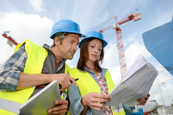 Construction manager and engineer working on building site Stock Photo ...