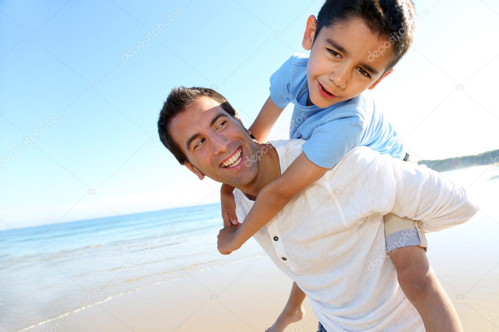 Father holding son on his shoulders at the beach Stock Photo by ...