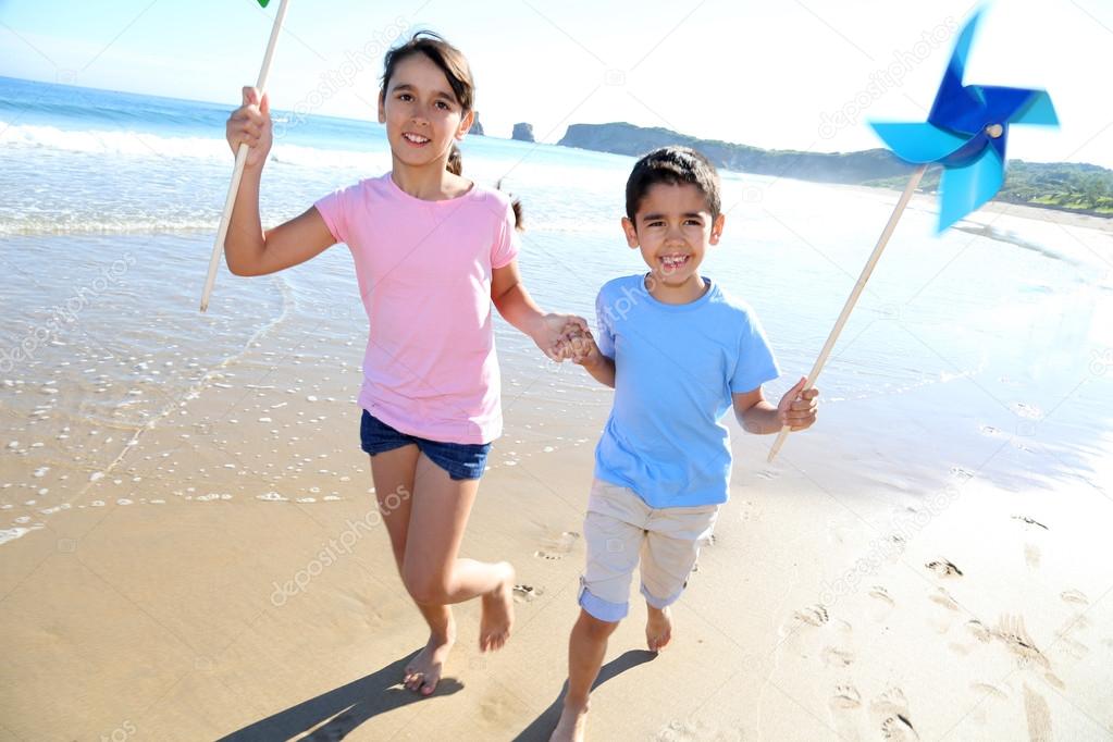 Kids running on the beach with swirls — Stock Photo © Goodluz #13937241