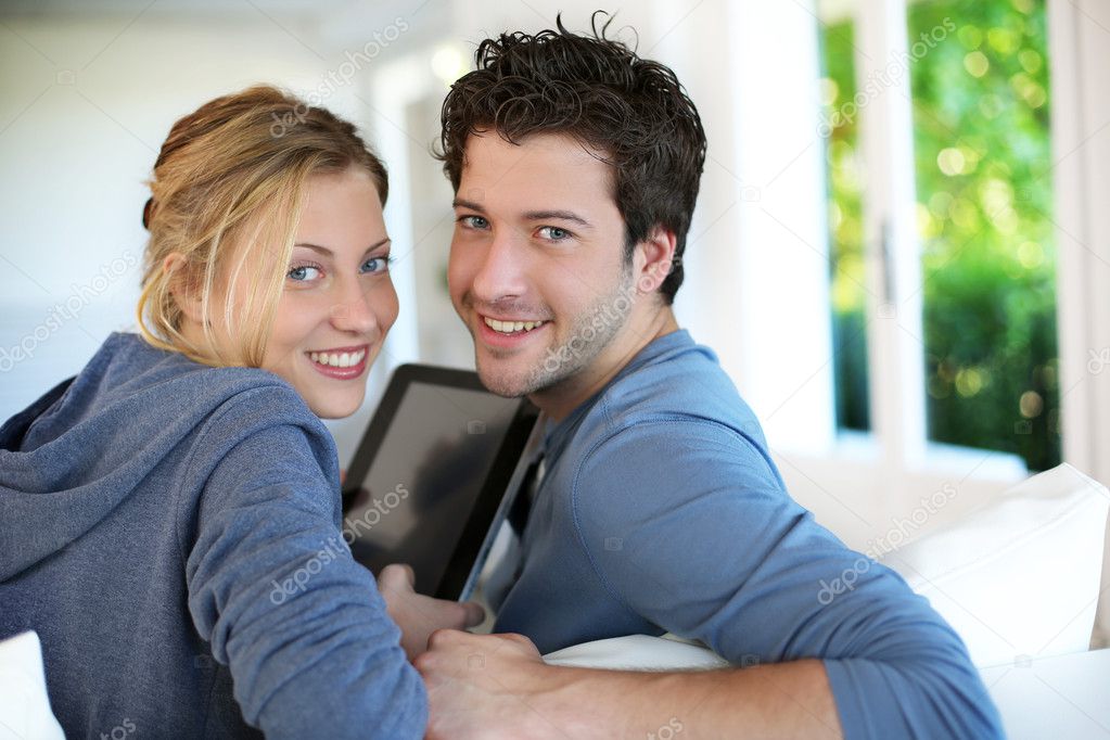Young couple using electronic tablet — Stock Photo © Goodluz #13938309