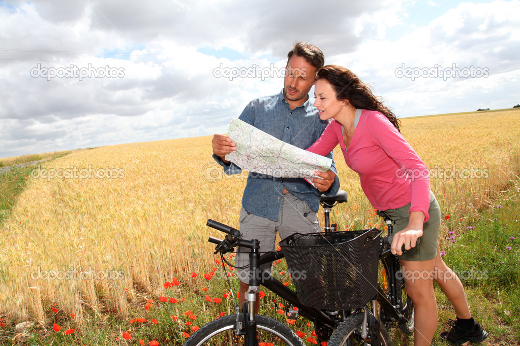 Couple riding looking at map on bike ride — Stock Photo © Goodluz #18214847