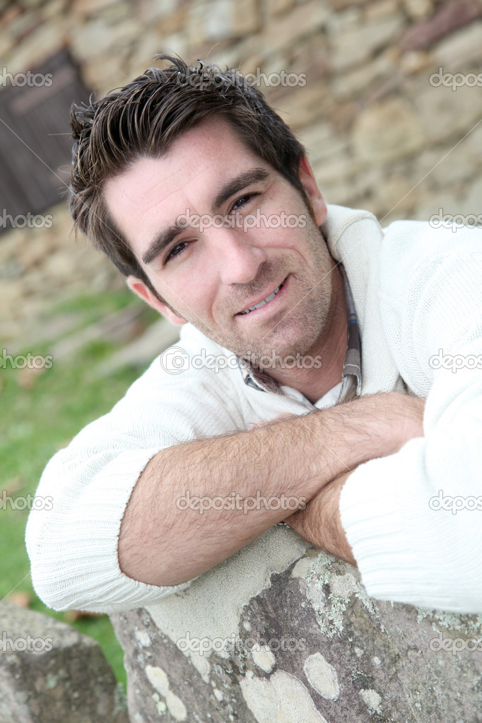 Man standing in front of stone house Stock Photo by ©Goodluz 18259565