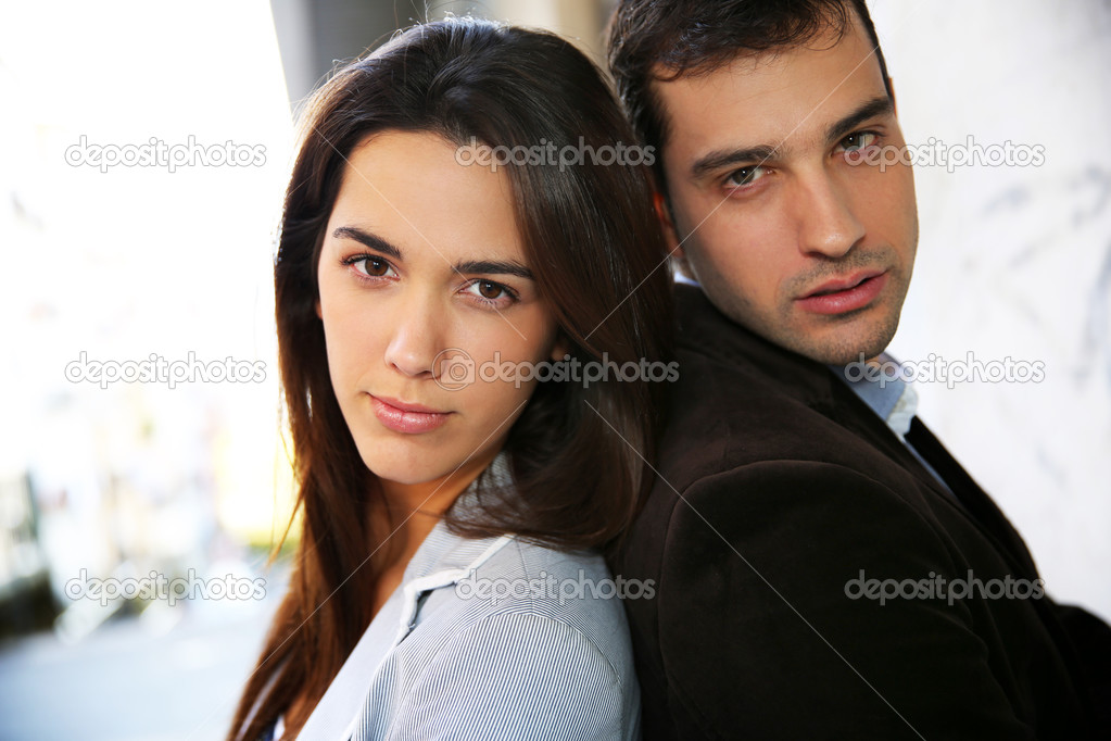 Serious couple standing in town back to back — Stock Photo © Goodluz ...