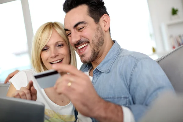Cheerful couple at home doing online shopping - Stock Image - Everypixel