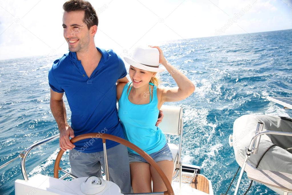 Young couple navigating on a yacht in caribbean sea — Stock Photo ...