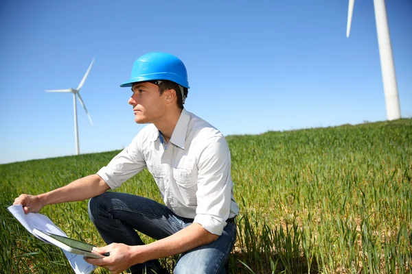 Engineer in wheat field checking on turbine production - Stock Image ...