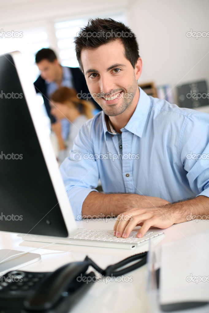 Man working on desktop computer Stock Photo by ©Goodluz 35265591